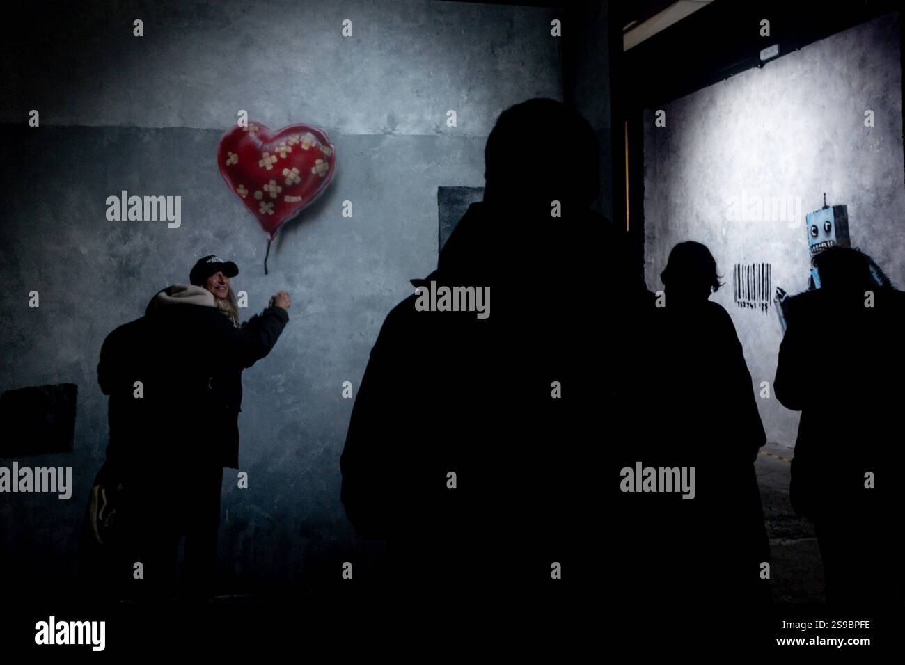 Several people walk through the permanent exhibition of Banksy's works ...