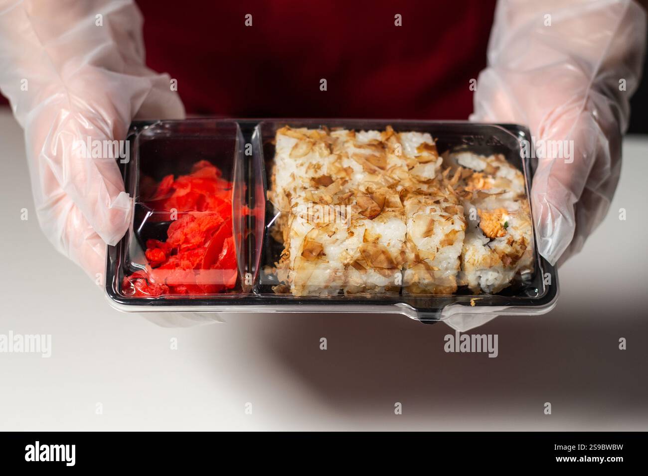 Sushi to go concept. Take away box with sushi rolls in woman hands in ...