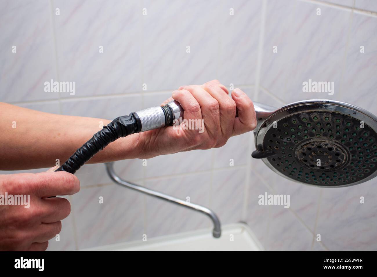 Woman changing broken shower hose in bathroom. Female plumber hands ...
