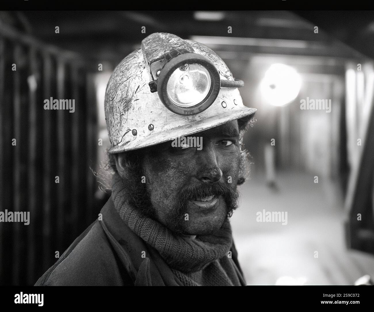 Young coal miner with his face covered in coal dust after working a ...