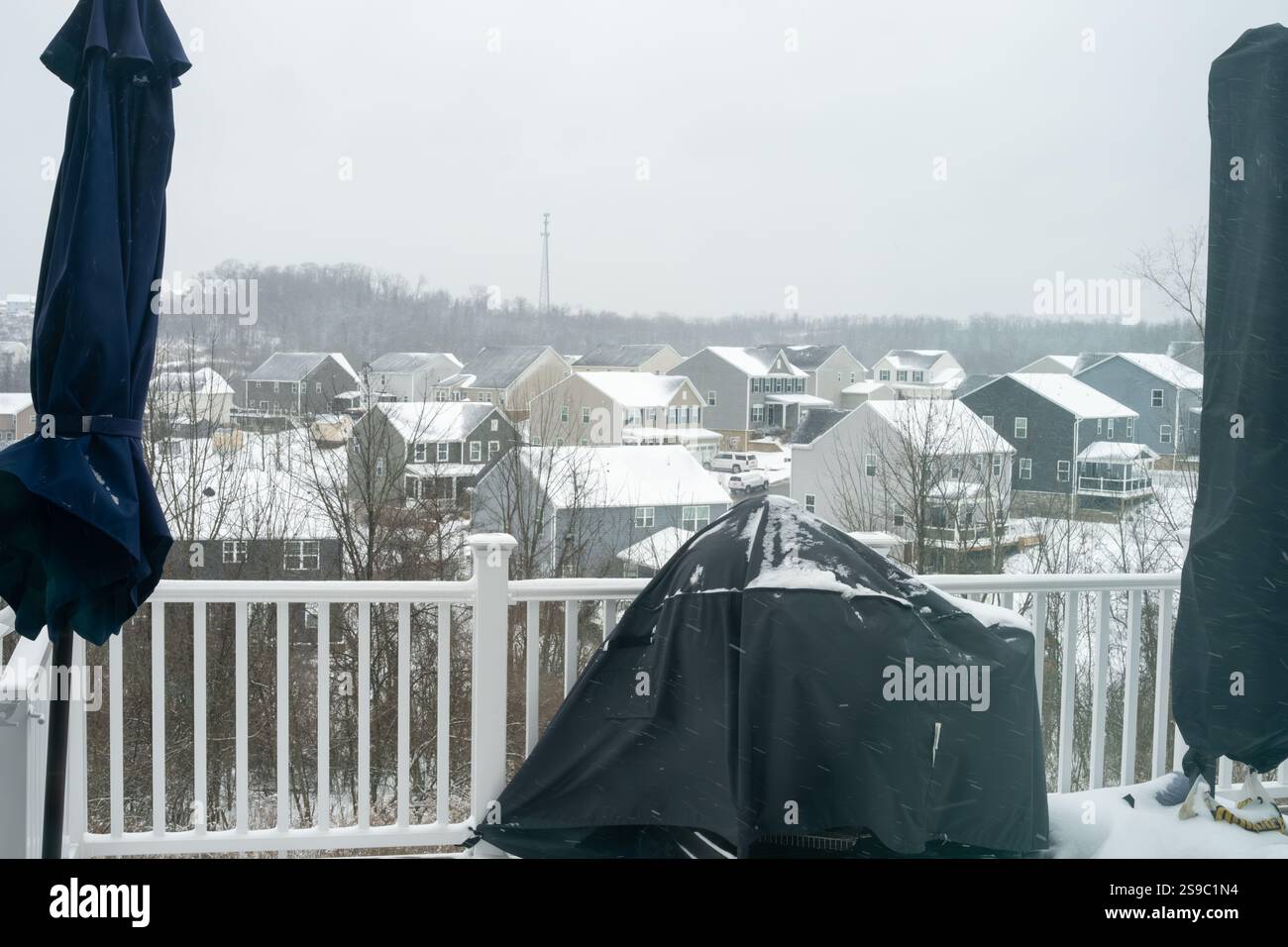 A thick layer of snow covers houses and streets while flurries continue ...