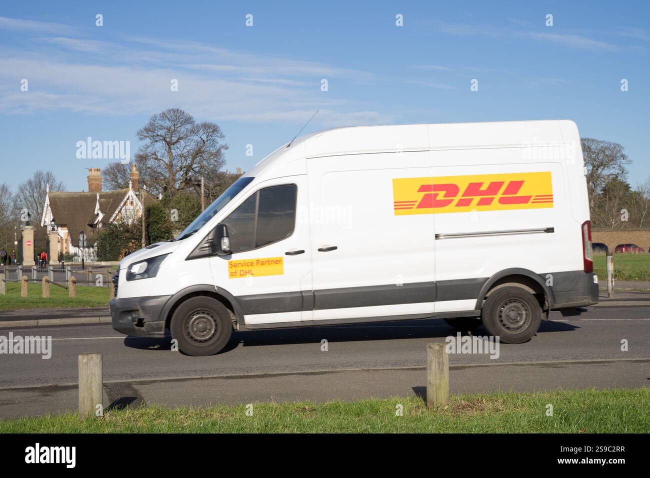 side view of DHL parcel delivery van in transit , out on the road near ...