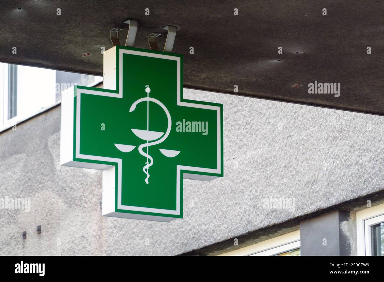 Asclepius staff symbol on green cross of pharmacy store Stock Photo - Alamy