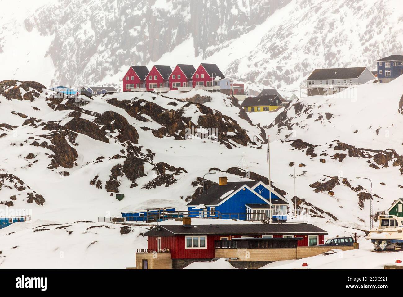 Inuit living houses and red church with mountains in the background ...