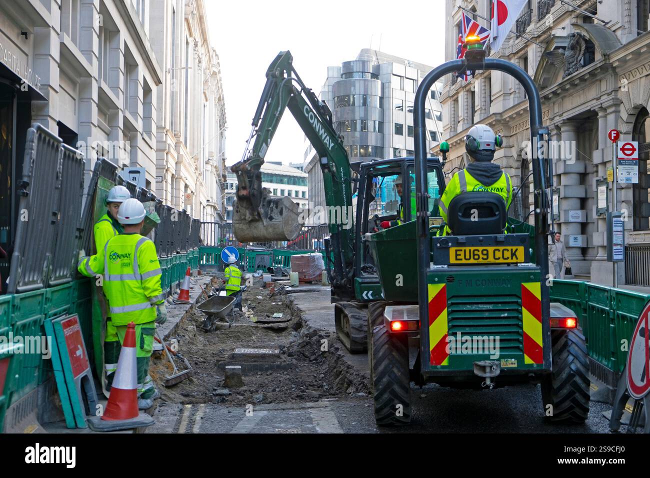 Roadworks workmen digger and equipment digging up the road on King ...