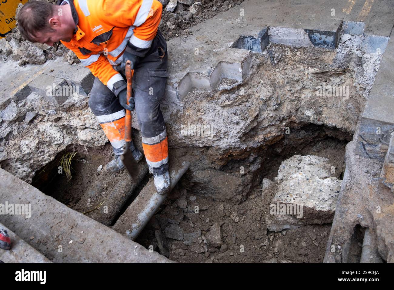 Workman digging up the pavement near Farringdon Station exposing gas ...