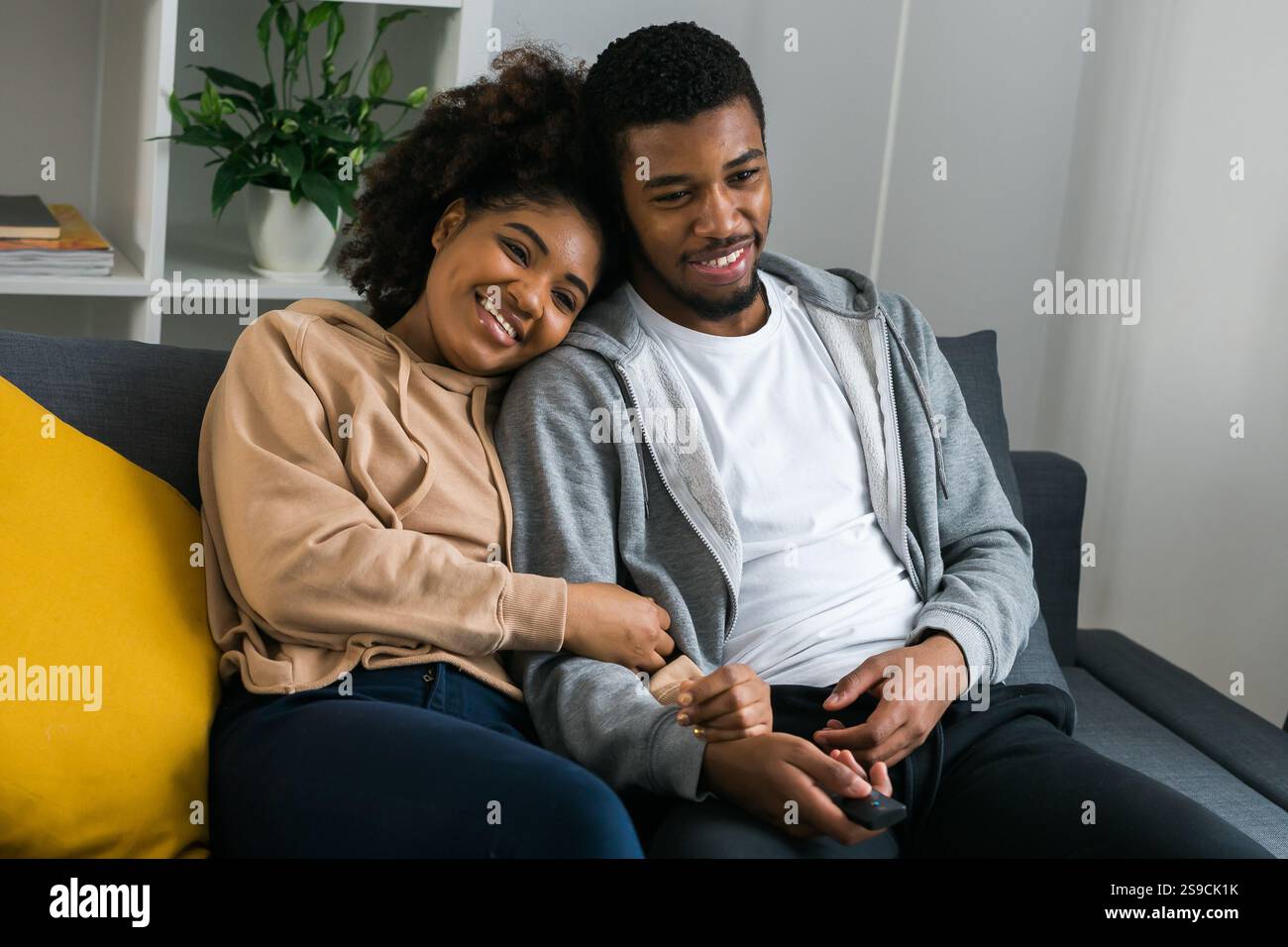 African American couple wife husband watching movie. Family pastime and leisure, watch ...