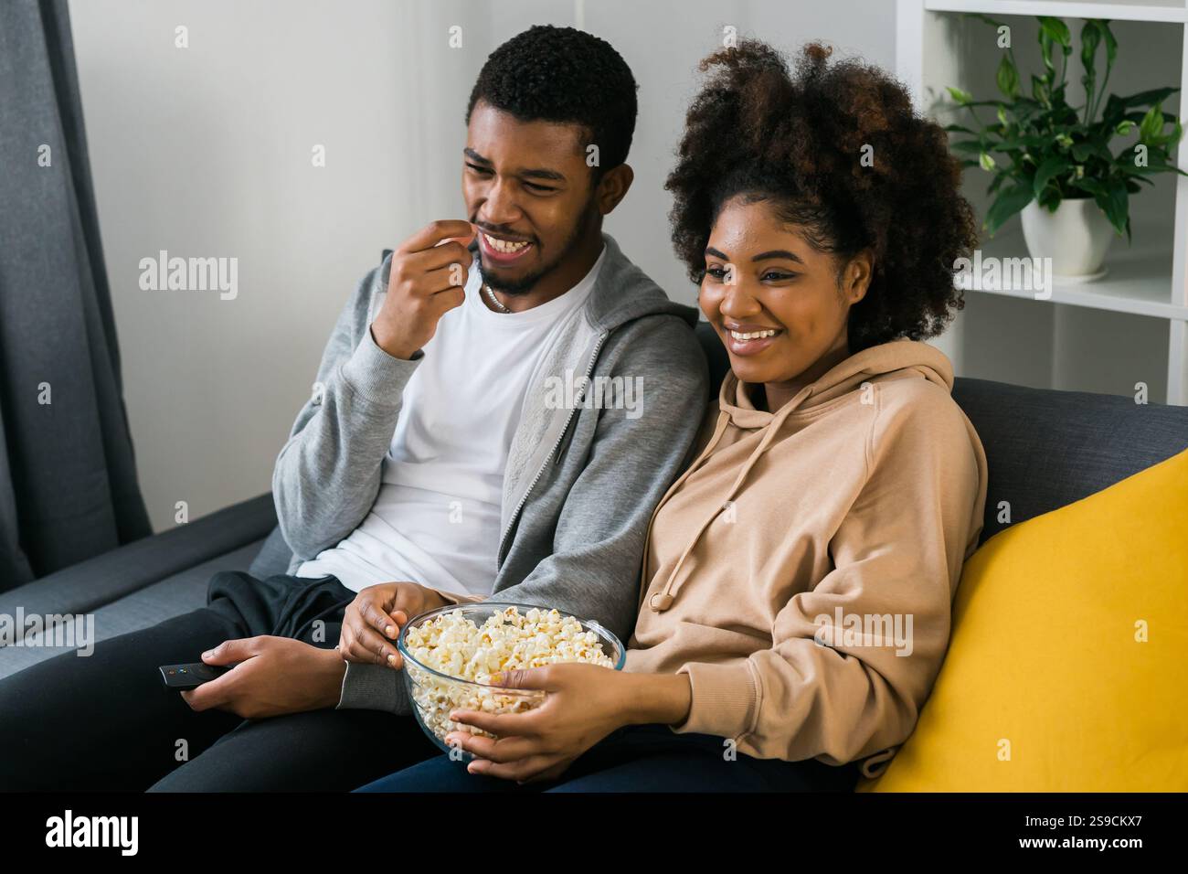 African American couple wife husband watching movie. Family pastime and leisure, watch ...