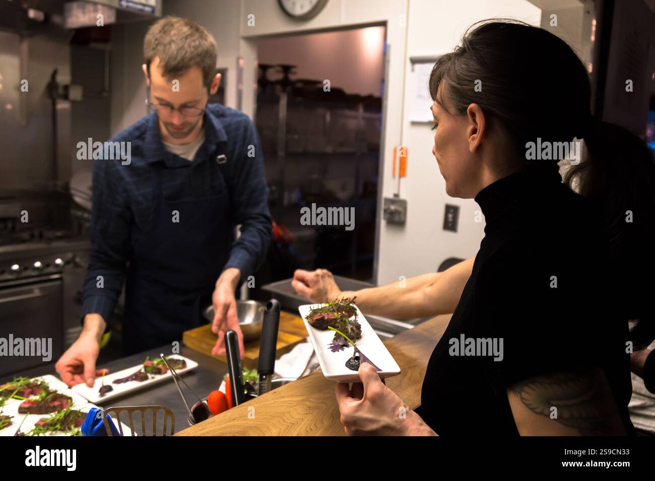 Chef Plating Gourmet Dishes in Open Kitchen Interacting with Customer ...