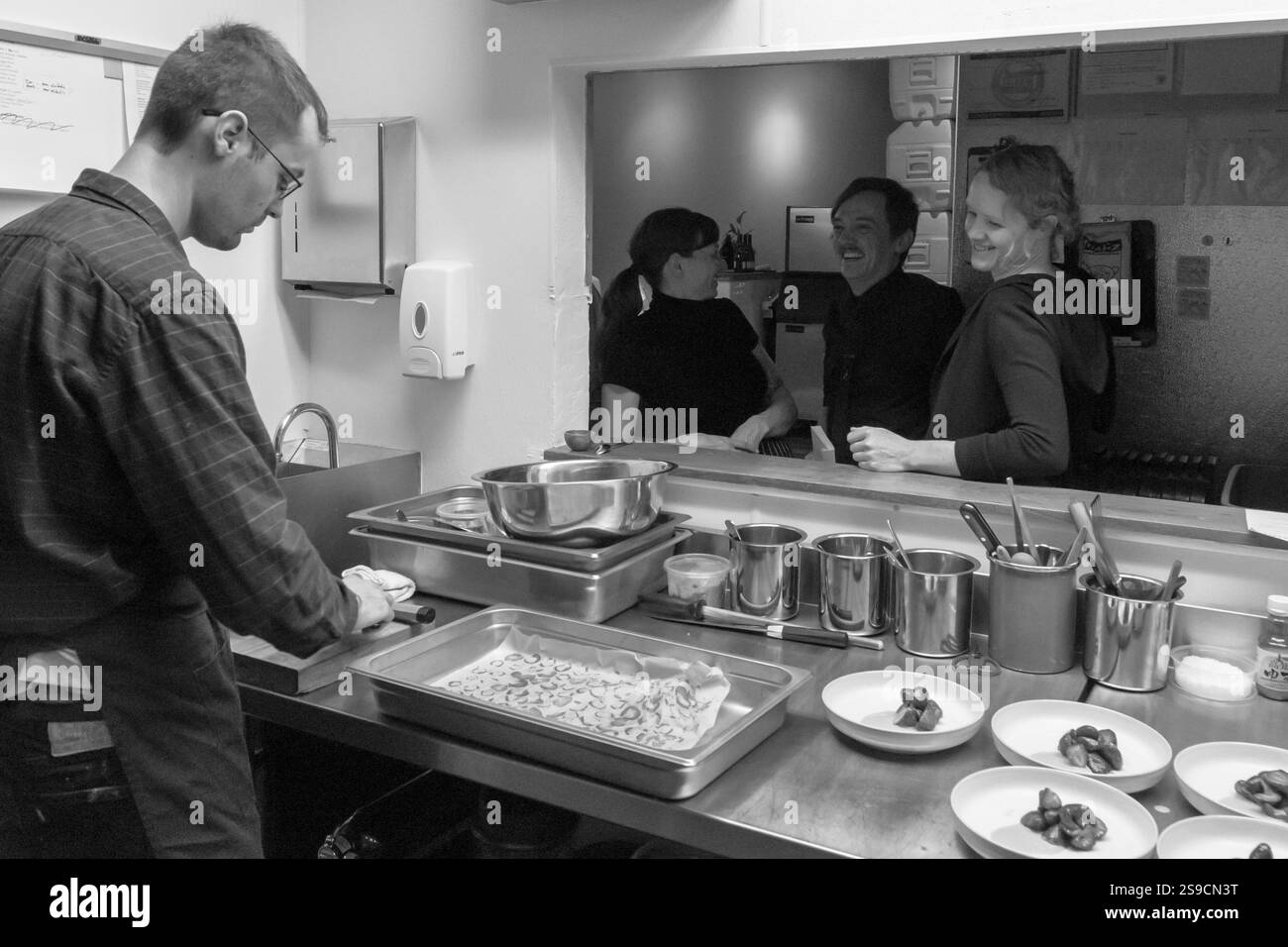 Commercial Kitchen Team Preparing Dishes and Socializing in a ...