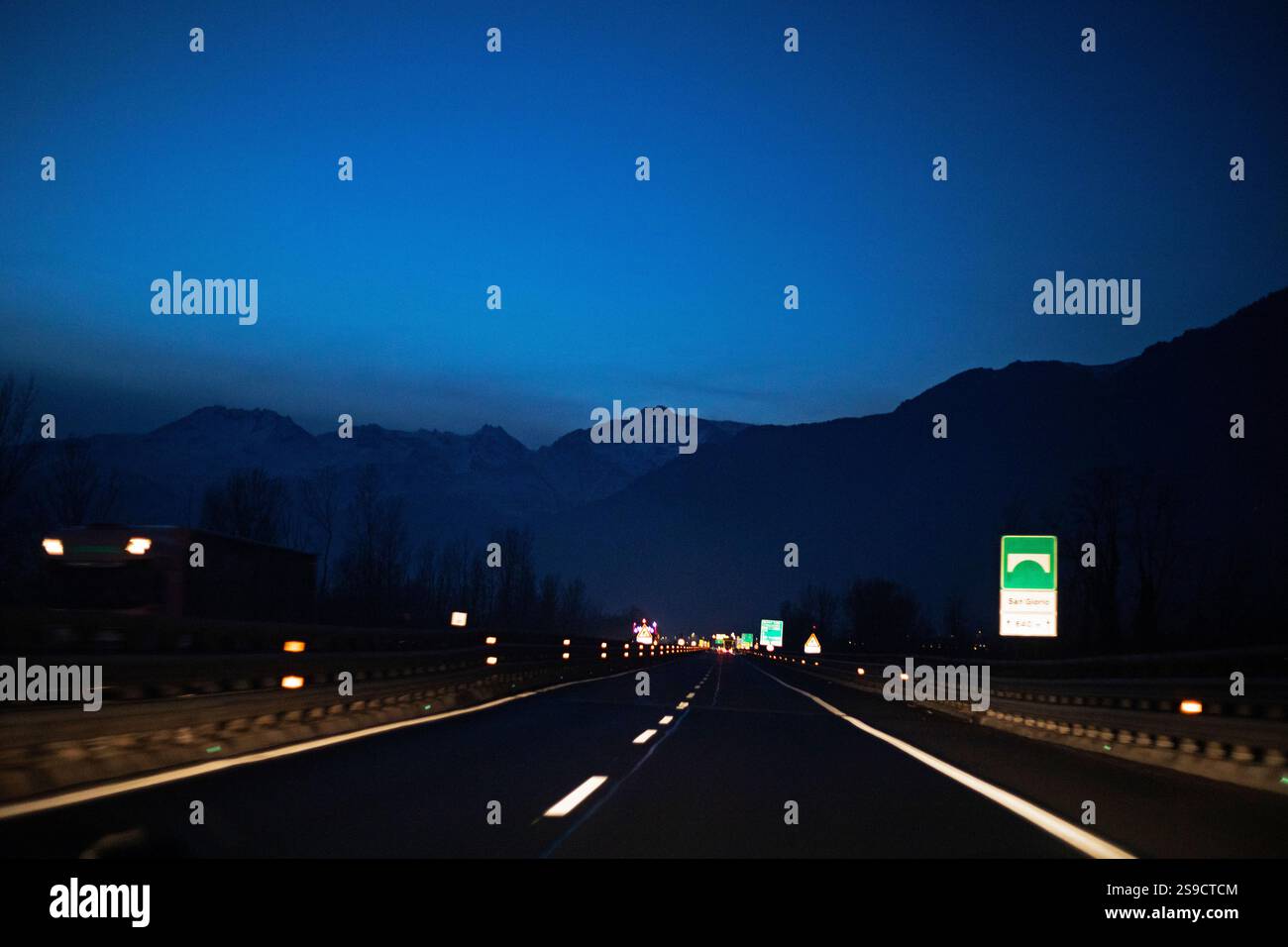 beautiful illuminated toll road in the Alps at night. car travel in ...