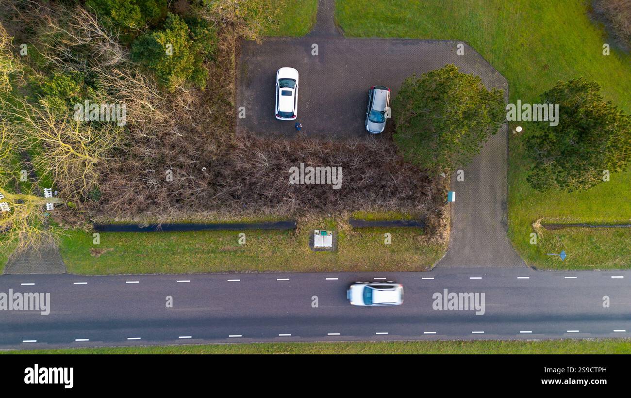 Aerial view of a roadside parking area with two parked cars, surrounded ...