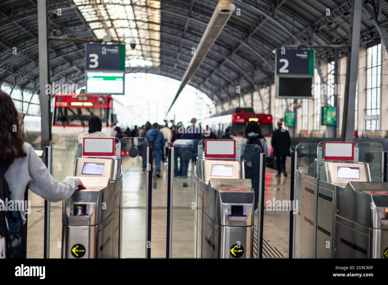 Tourist woman is validating ticket at station ticket barrier passing ...