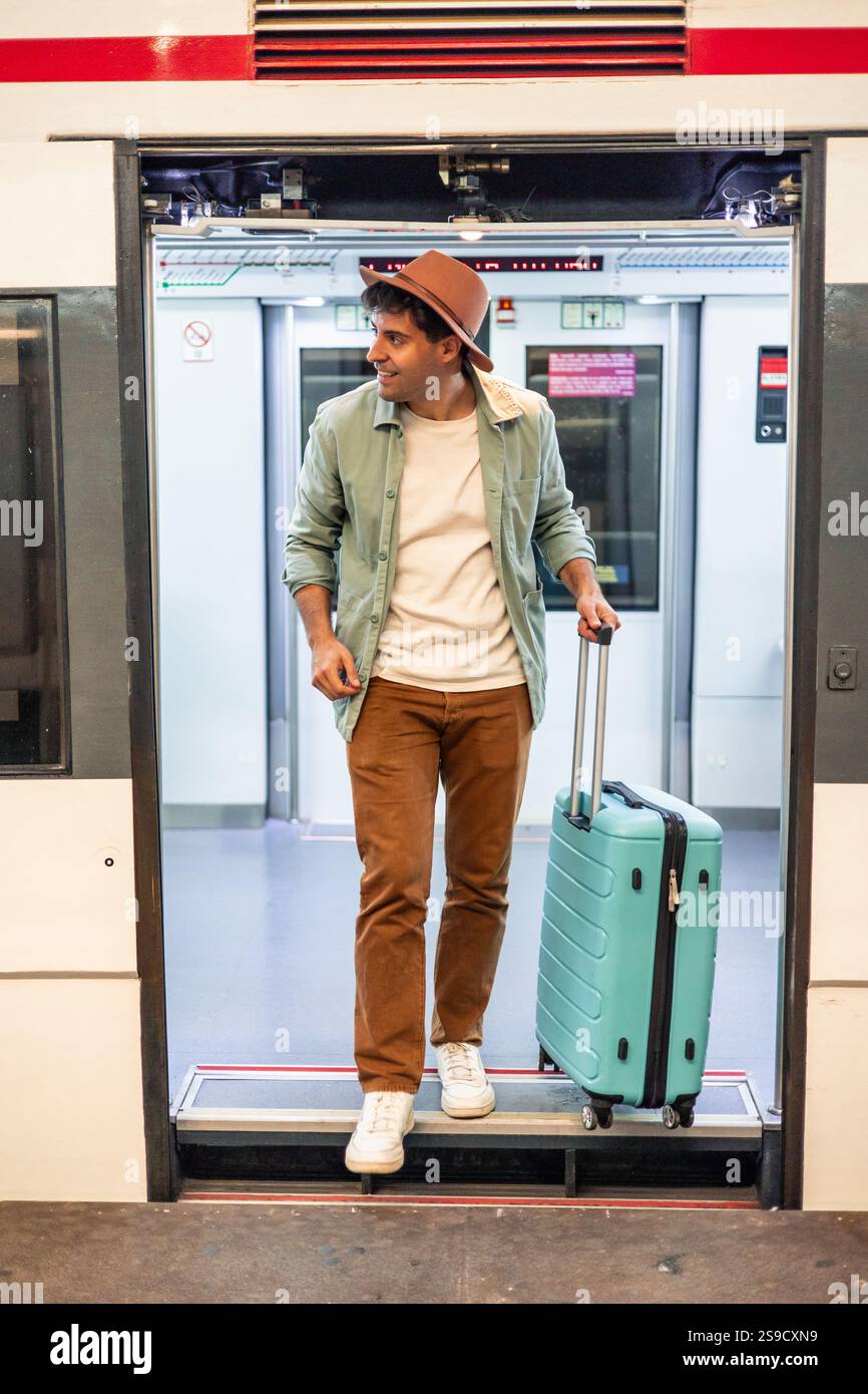 vertical Young latin male tourist wearing hat and casual clothes is ...
