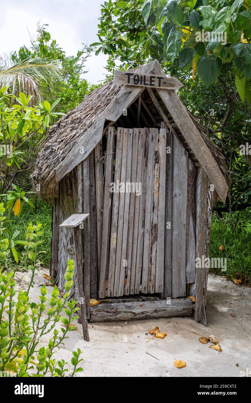 Rustic outdoor toilet with thatched roof in the lush, tropical ...