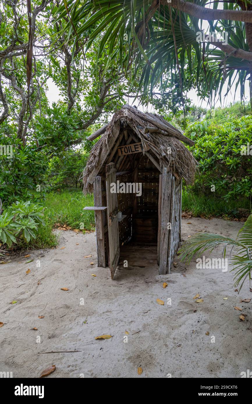 Rustic outdoor toilet with thatched roof in the lush, tropical ...