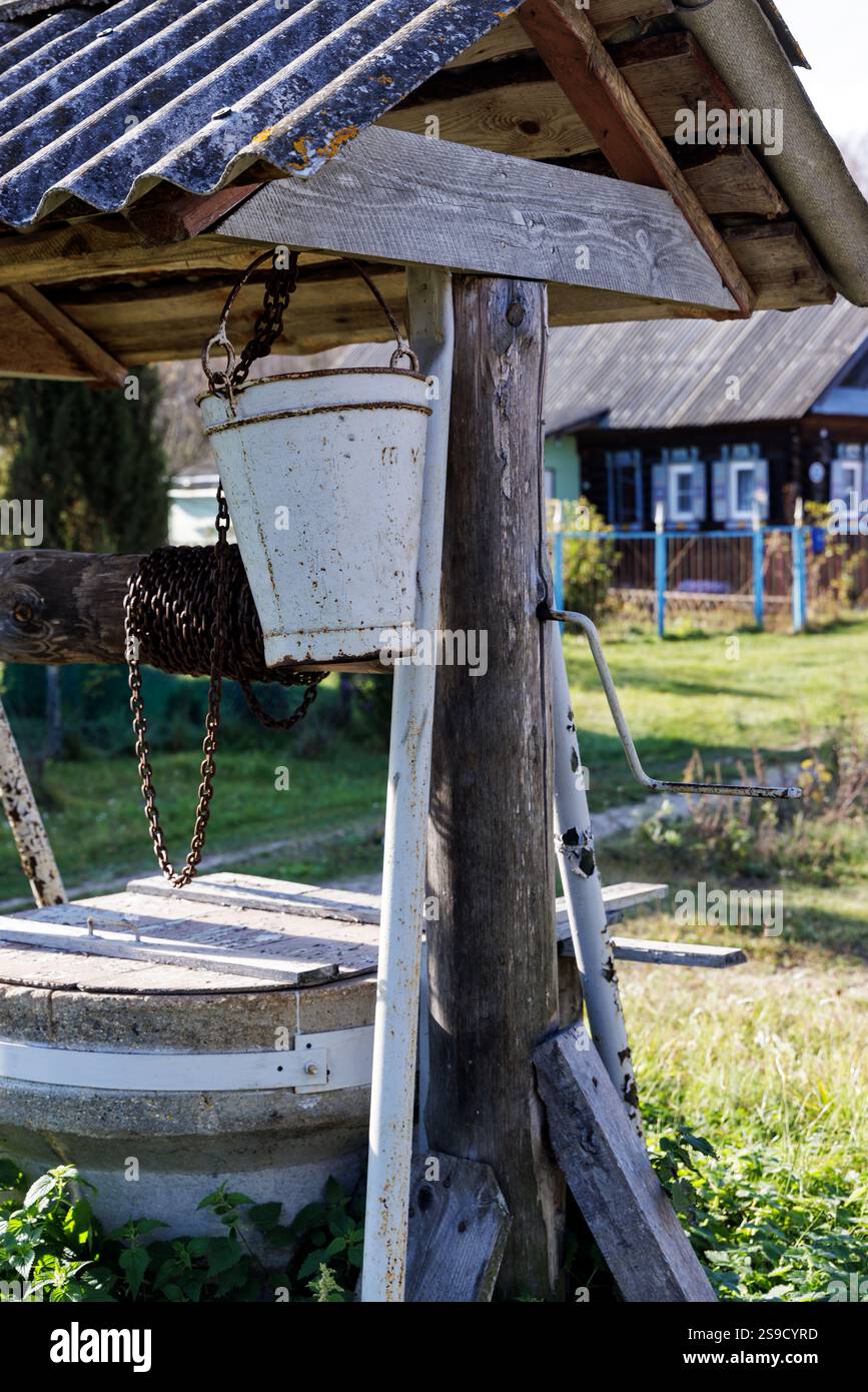 A detailed view of a rustic village well featuring a weathered metal ...