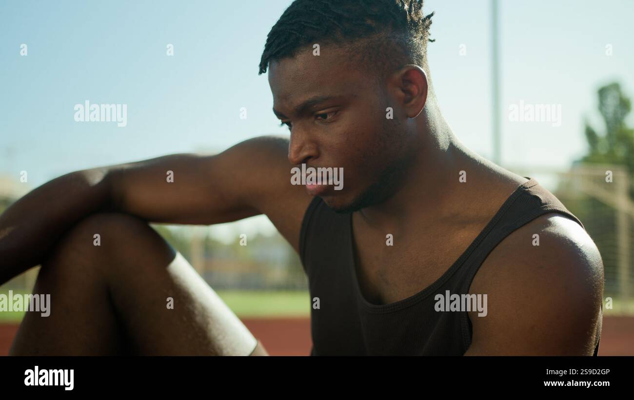 African American footballer sportsman sit on field suffer pain sharp ...