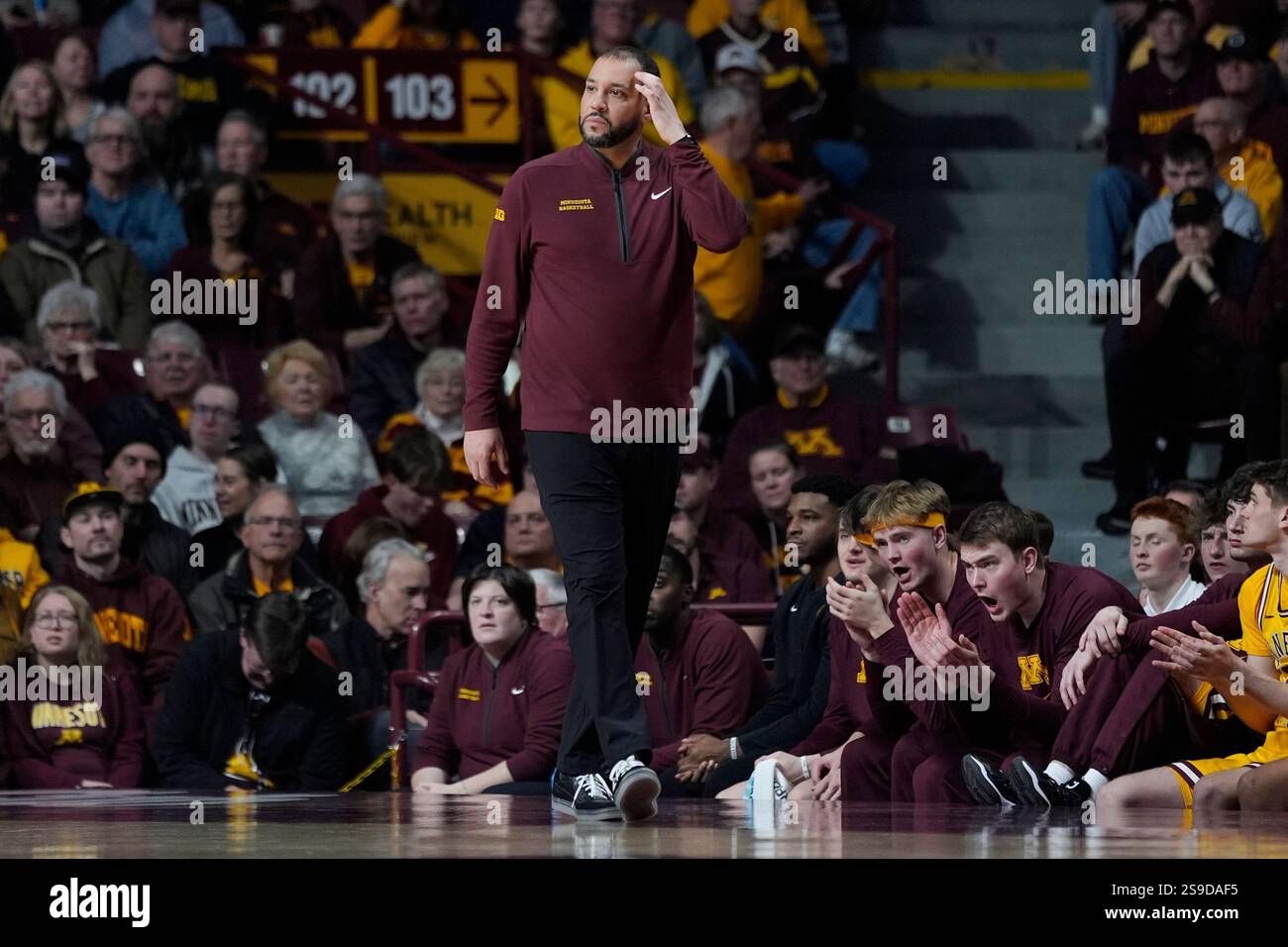 Minnesota head coach Ben Johnson, center, watches play during the ...