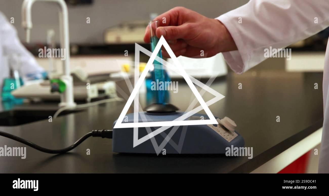 Hand holding test tube over laboratory equipment with triangle image ...