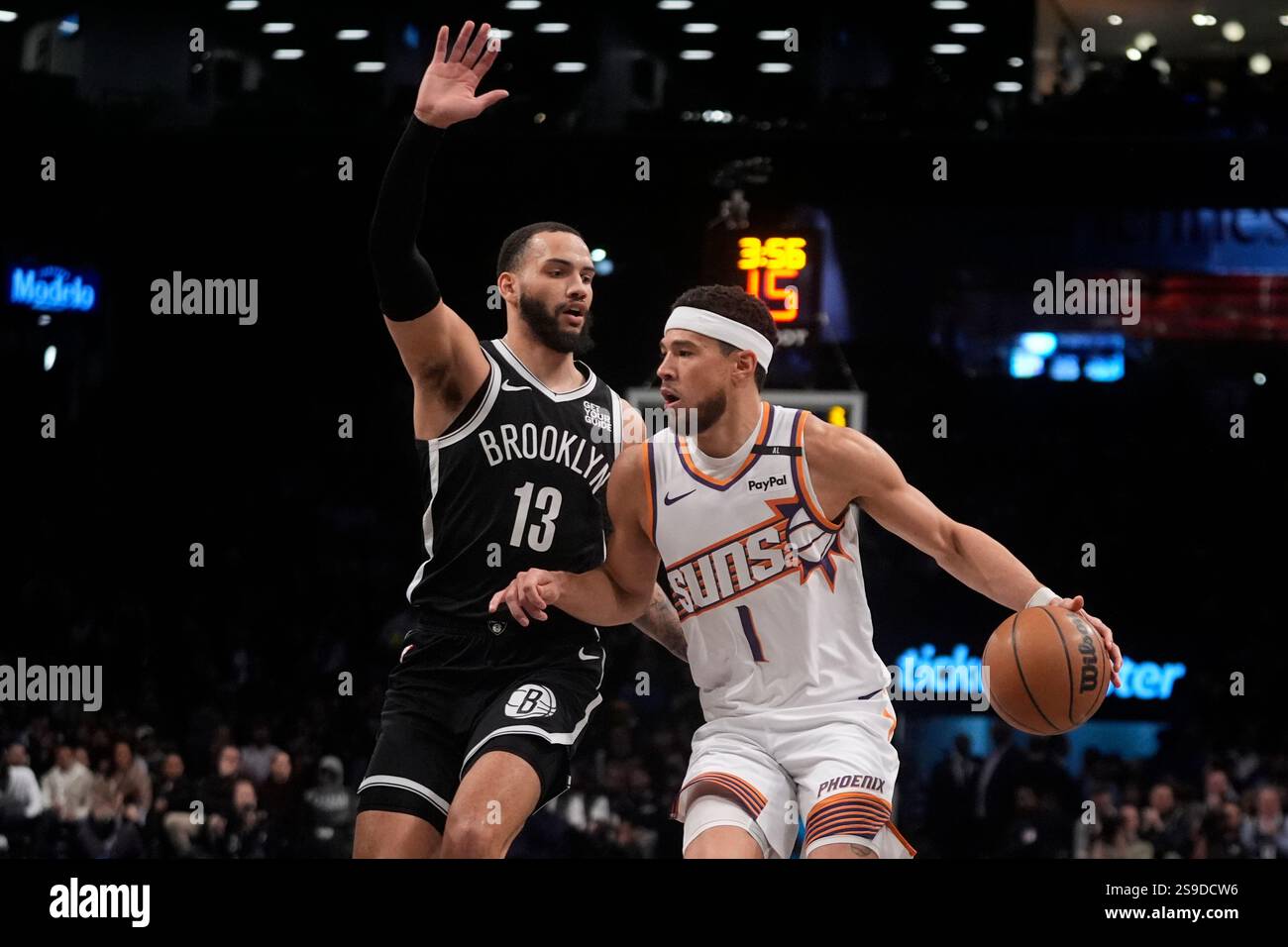 Brooklyn Nets' Tyrese Martin (13) defends Phoenix Suns' Devin Booker (1 ...