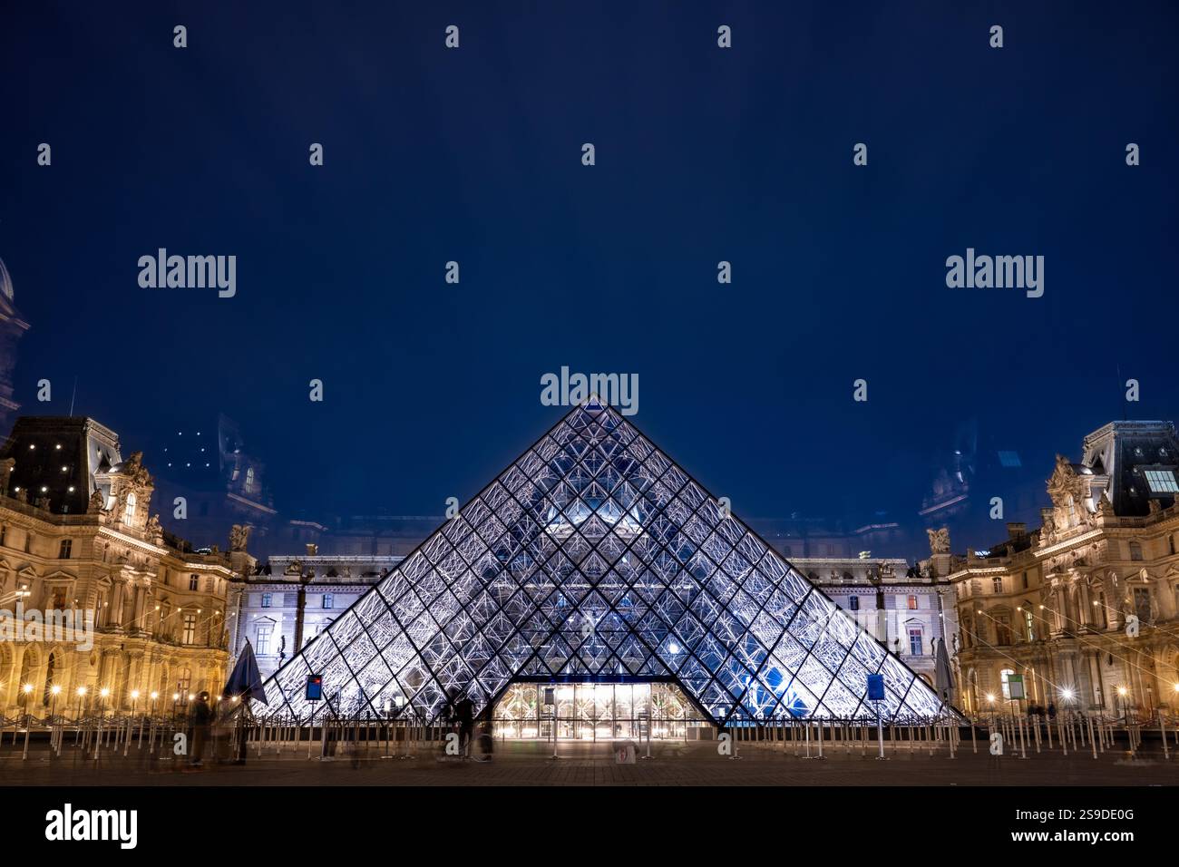 A photograph of the Louvre Museum captures its iconic glass pyramid ...