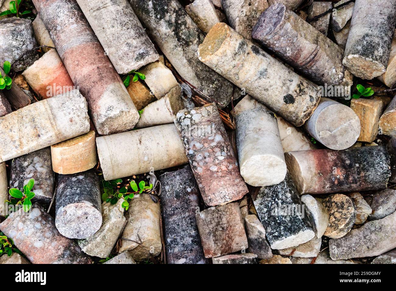 A pile of bricks and stones with some green grass in between. The pile ...