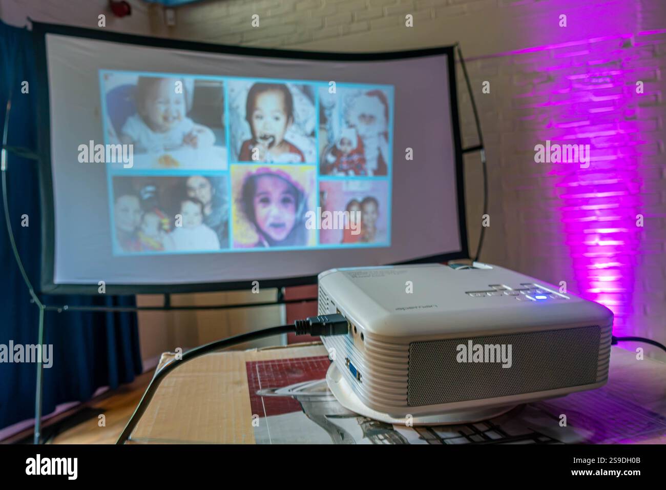 A projector projects a presentation showing photographs onto a screen Stock Photo - Alamy