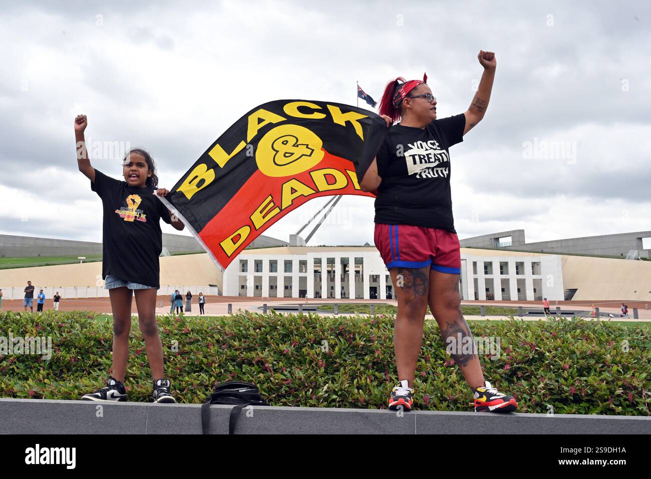 Protesters march past Parliament House during an Invasion Day rally in ...