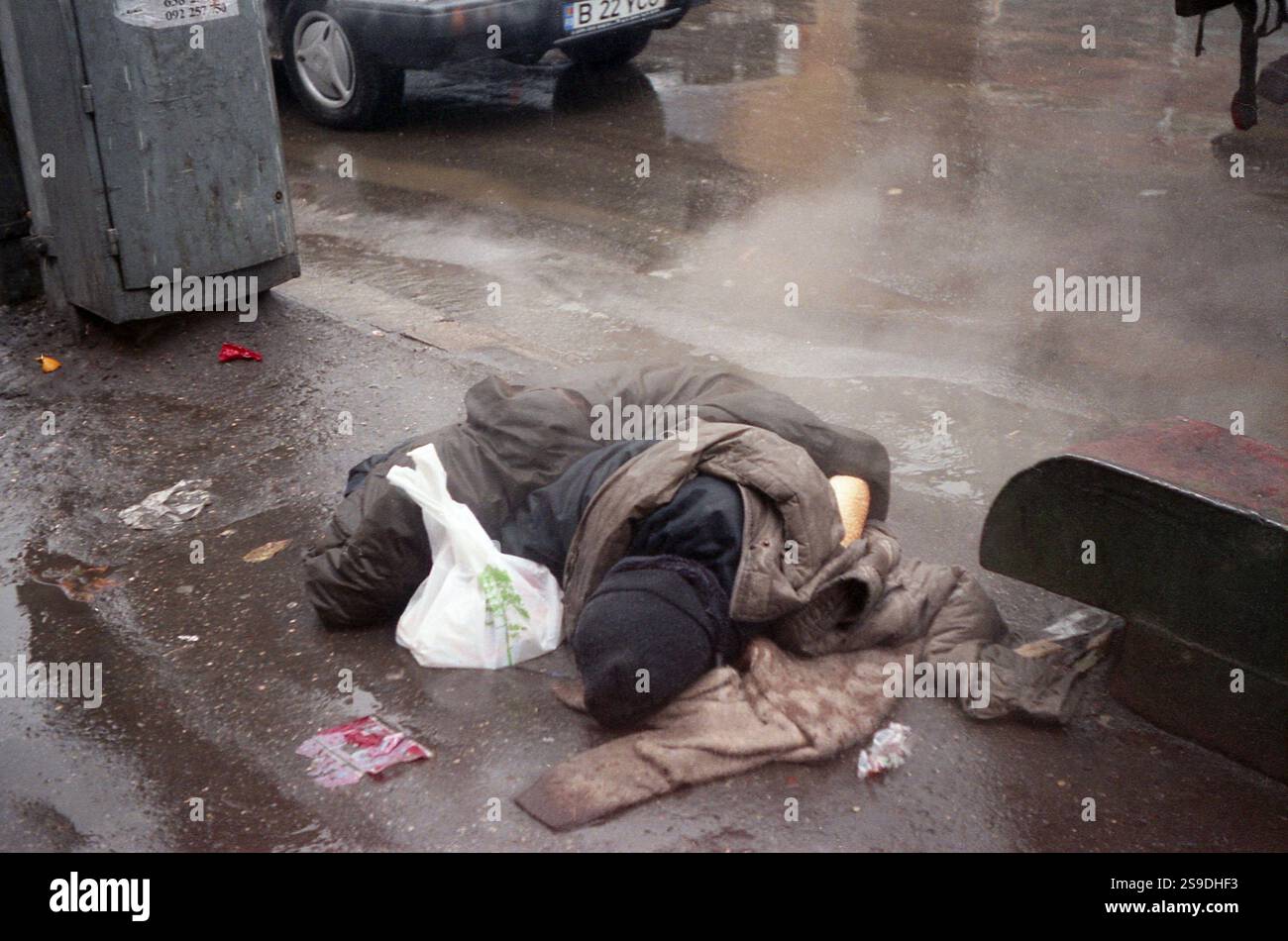 Bucharest, Romania, approx. 1998. Homeless man sleeping on a wet ...