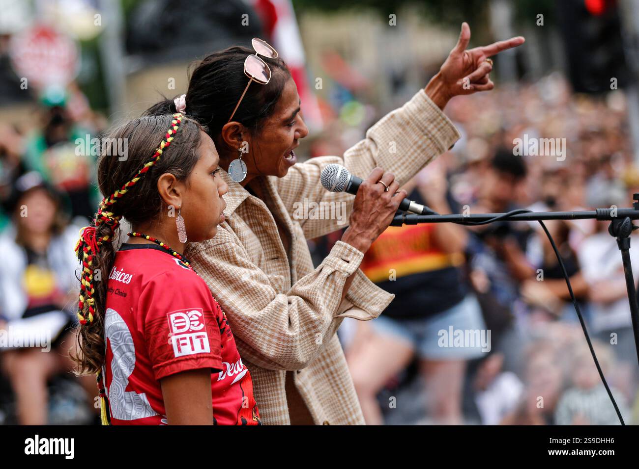 An Indigenous woman speaks passionately into a microphone outside the ...