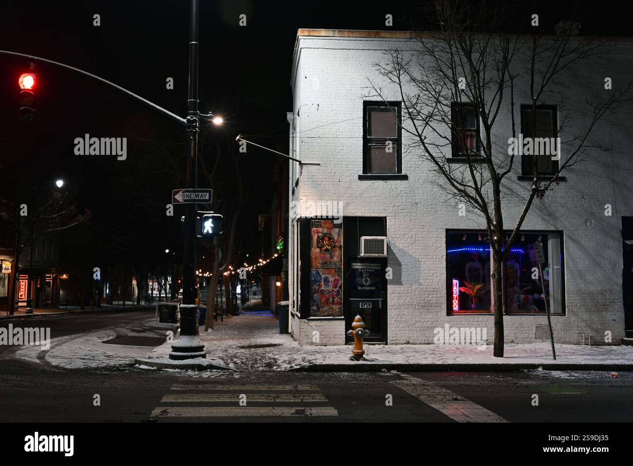 Snow covers the sidewalk in historic downtown Raleigh, NC, after dark ...