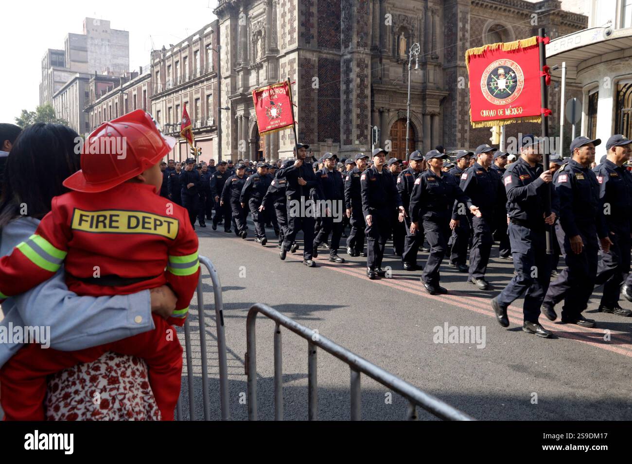 A woman with her son dressed as a firefighter watch the first Heroic ...