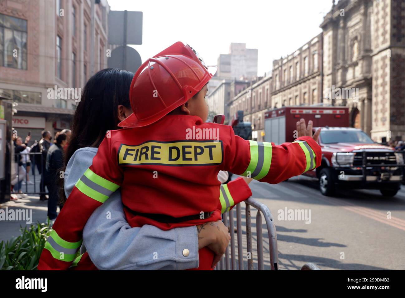 A woman with her son dressed as a firefighter watch the first Heroic ...