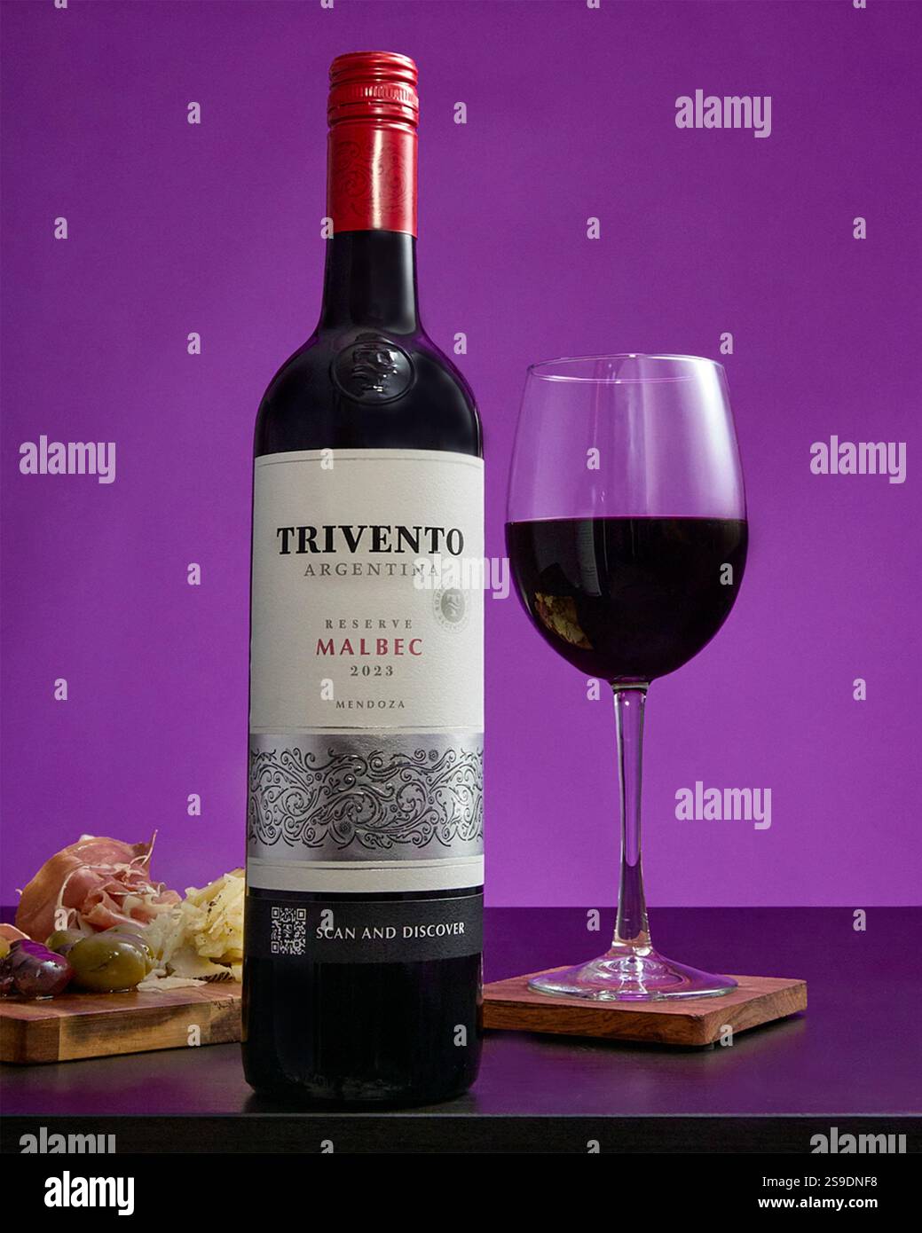 Red wine bottle and wine glass with appetizer prosciutto, Manchego ...