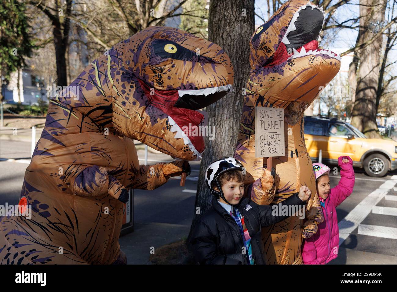 Two people wear dinosaur costumes against climate change. About 150 ...