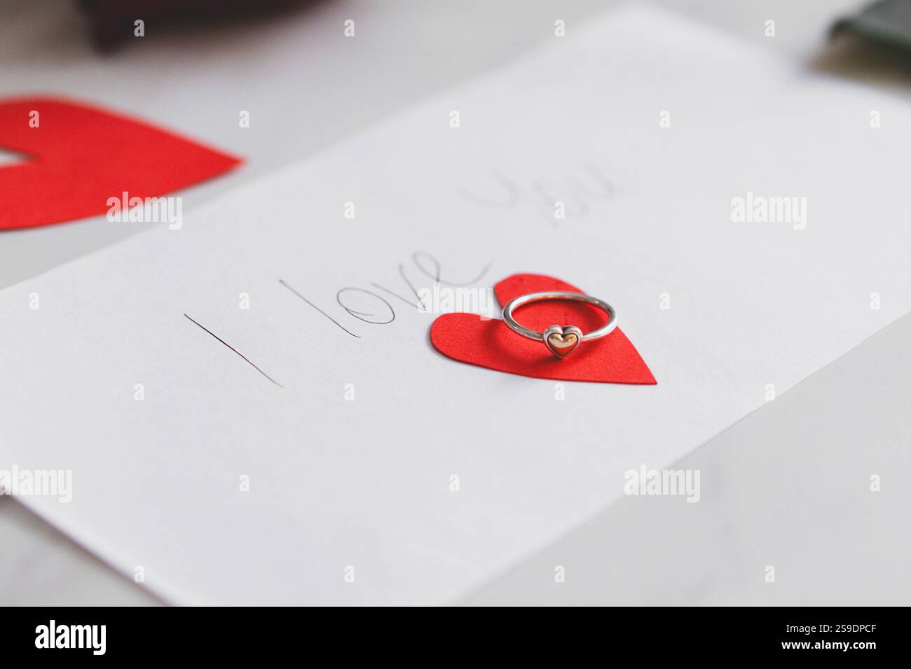 Heartfelt proposal on a handwritten note with a ring on a red paper ...