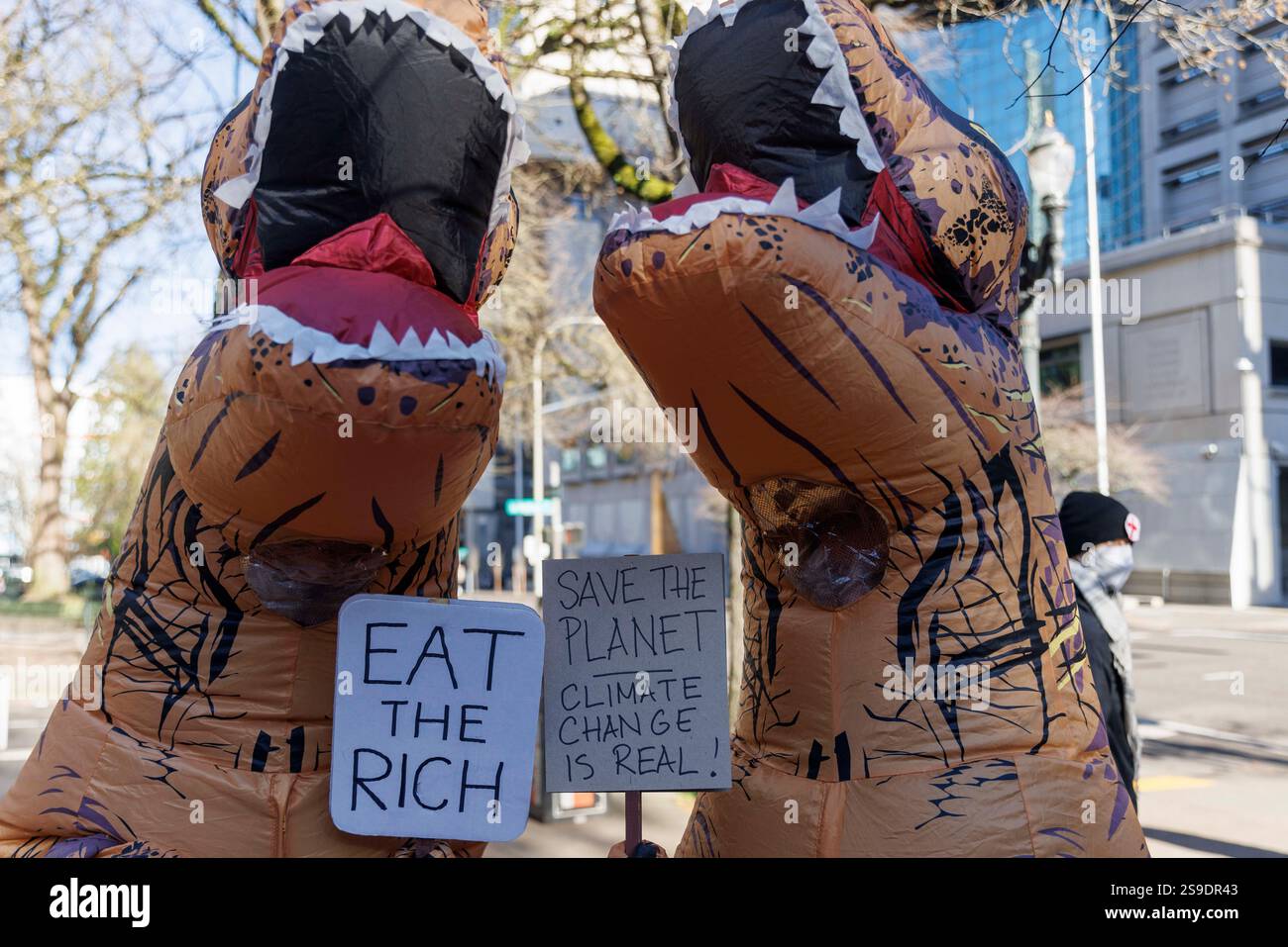 Two people wear dinosaur costumes against climate change. About 150 ...