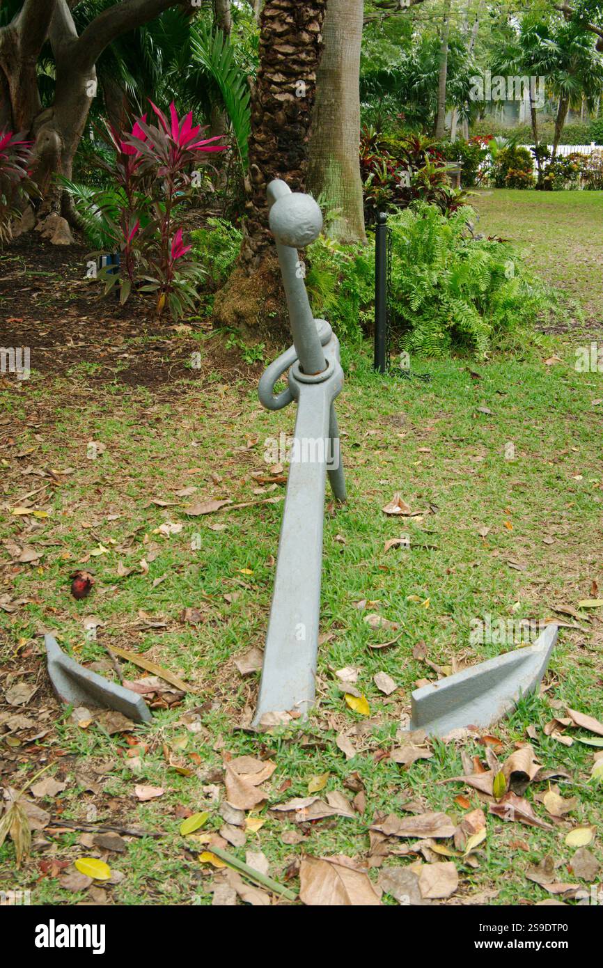 Vertical view Large Anchor laying on green grass.Trees and plants in ...