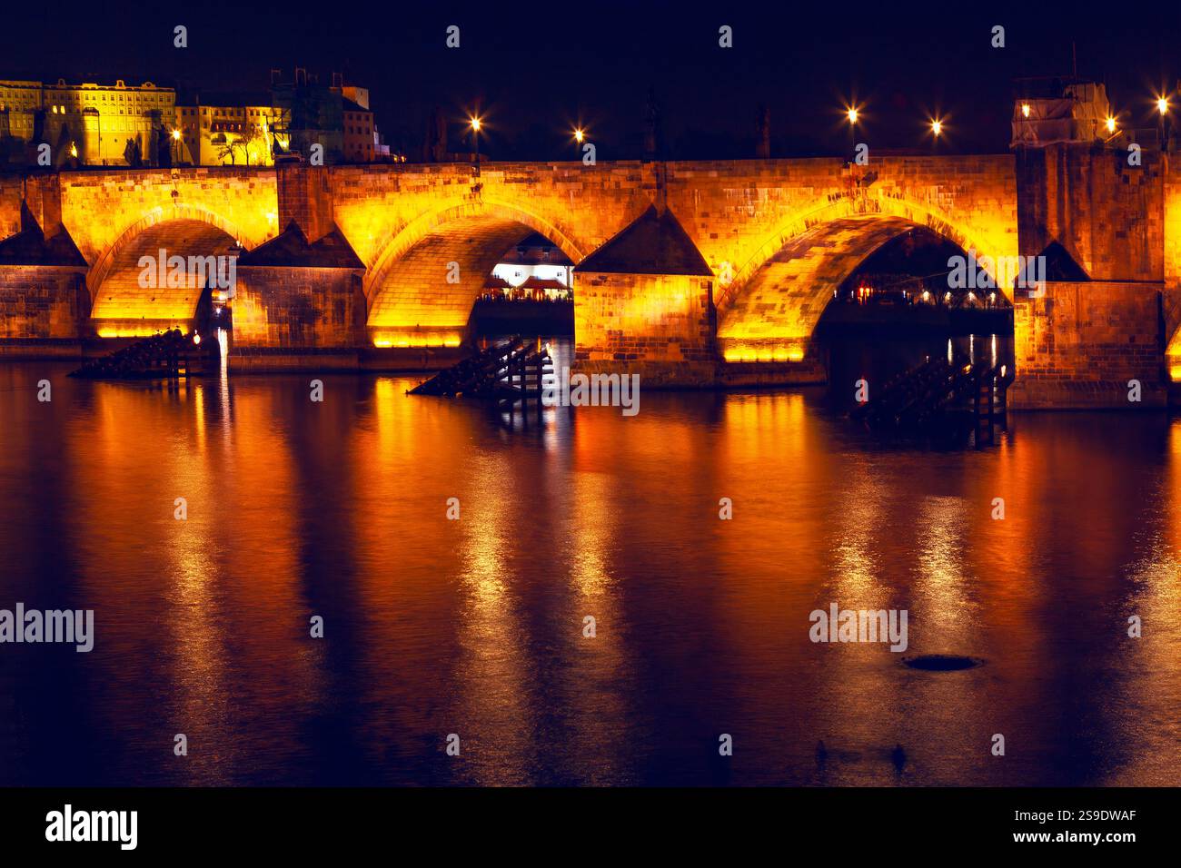 Charles Bridge in Prague at night, beautifully illuminated with golden ...