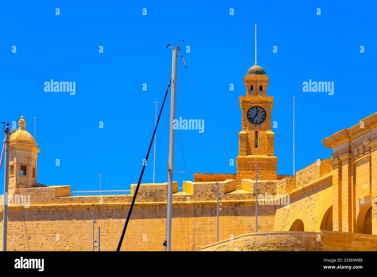 Historic stone fortification with a prominent clock tower under a clear ...