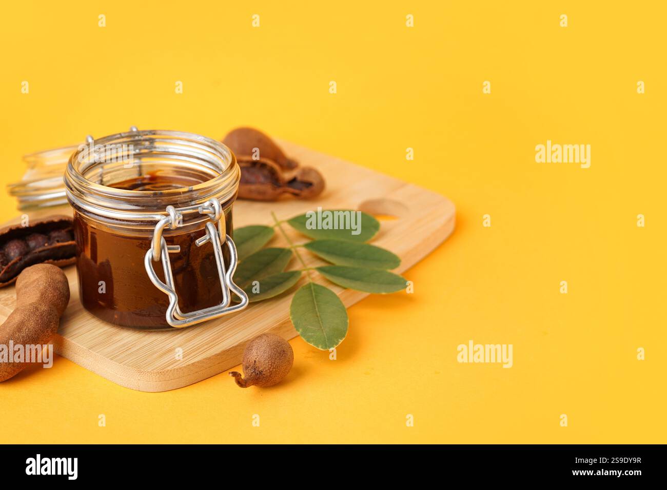 Jar with tasty tamarind jam with fruits on orange background Stock ...