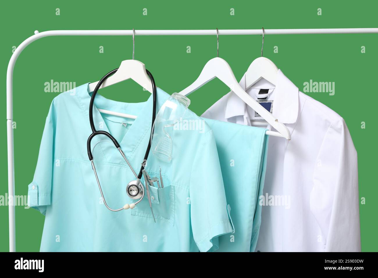 Medical uniform hanging on rack with stethoscope and dental instruments ...