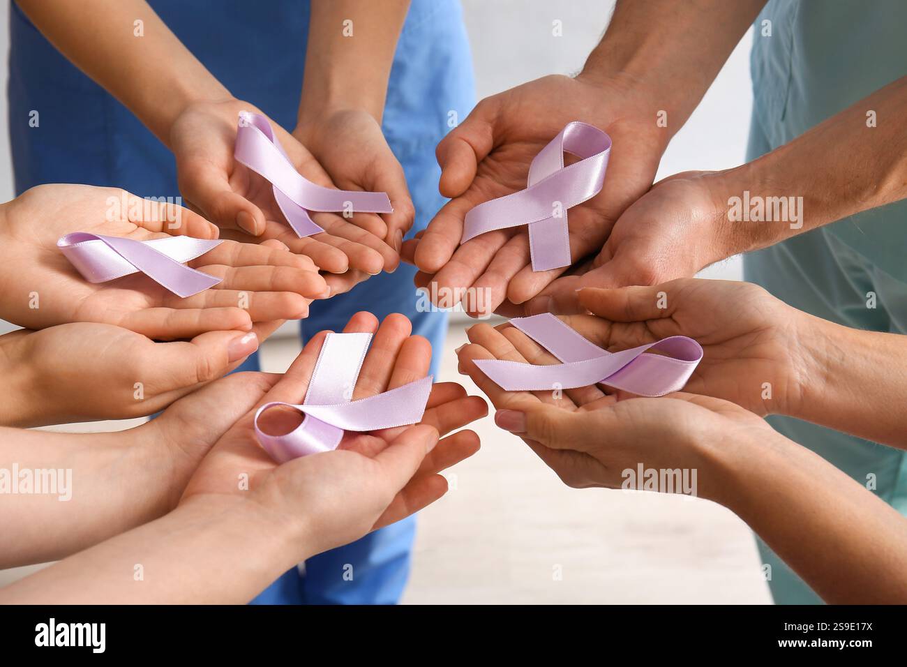 Doctors holding lilac awareness ribbons, closeup. World Cancer Day ...