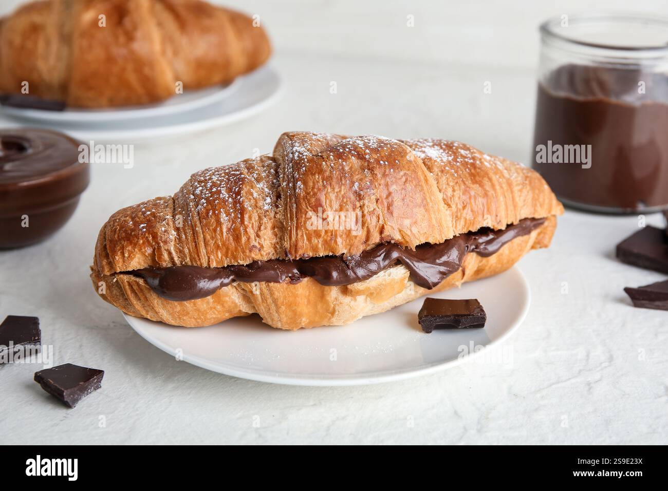 Plate of sweet croissant with chocolate spread on white background ...