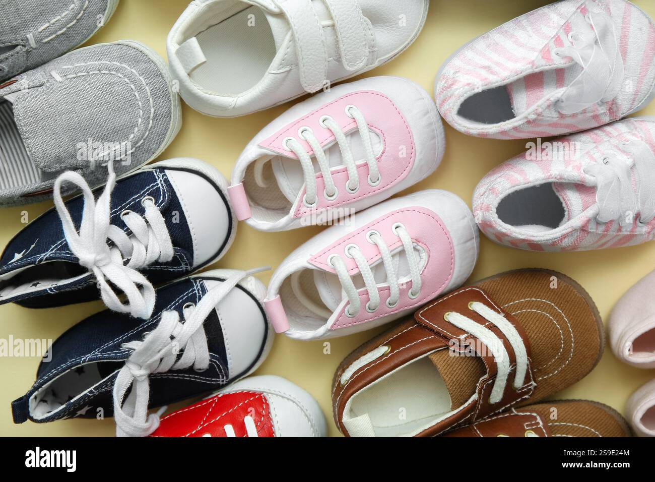 Different cute baby booties on yellow background Stock Photo - Alamy