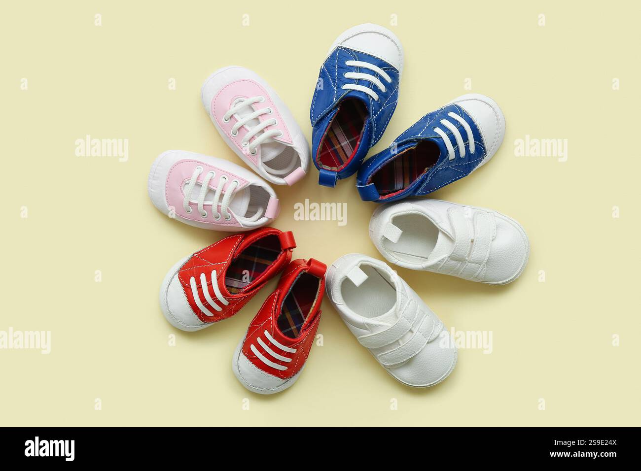 Different cute baby booties on yellow background Stock Photo - Alamy