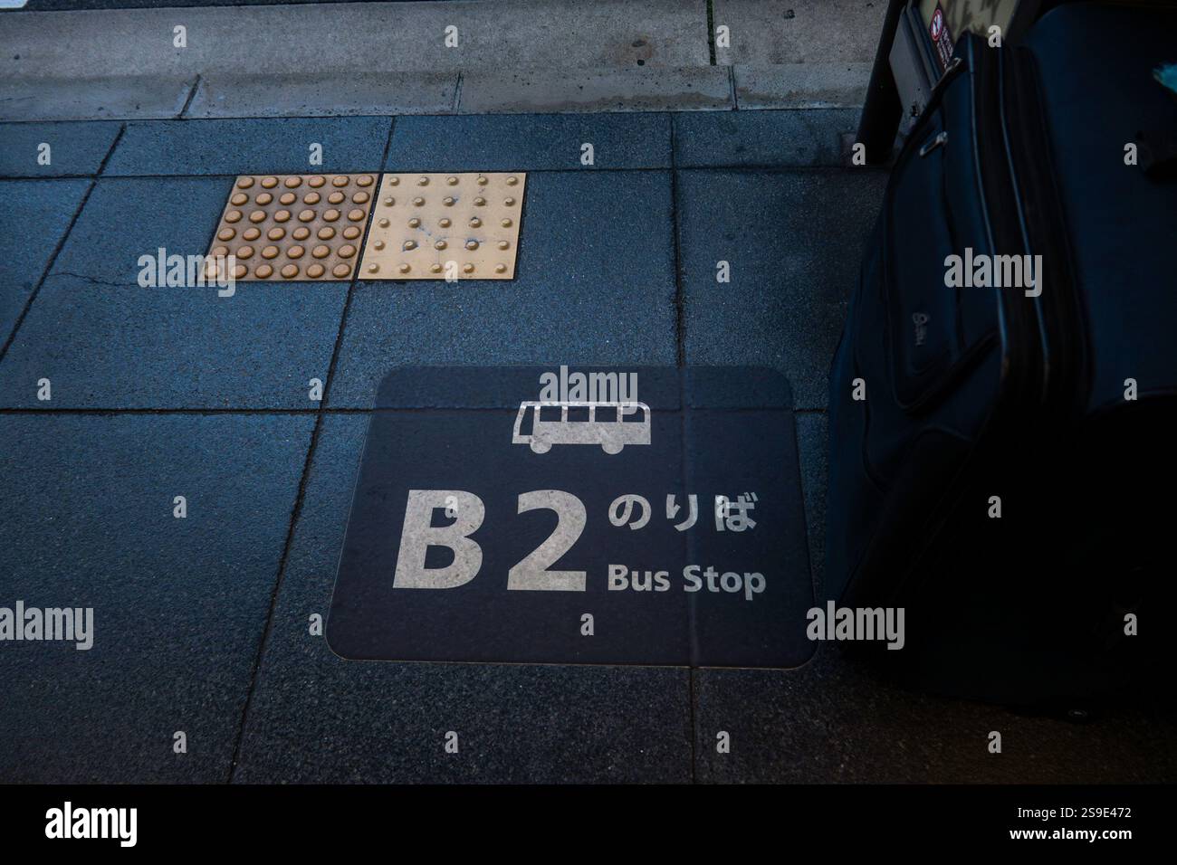 Bus stop signage in an urban area with tactile paving for visually ...