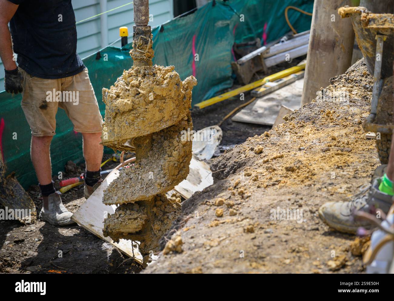 Digging hole machine at work. Hard soil excavated from deep ground for ...