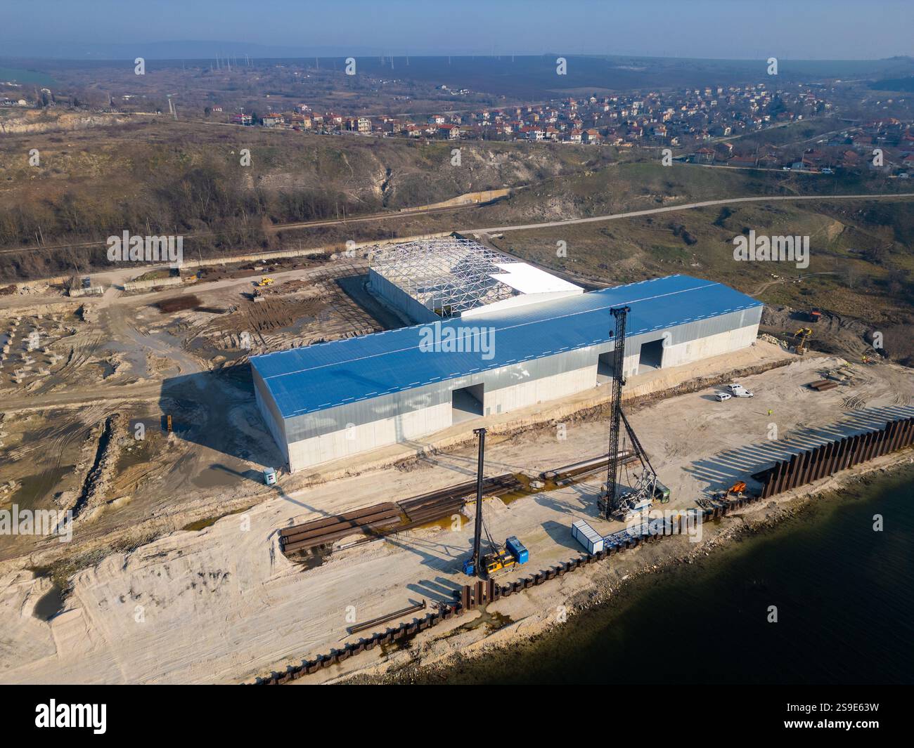 A construction site with a partially built warehouse featuring a steel ...